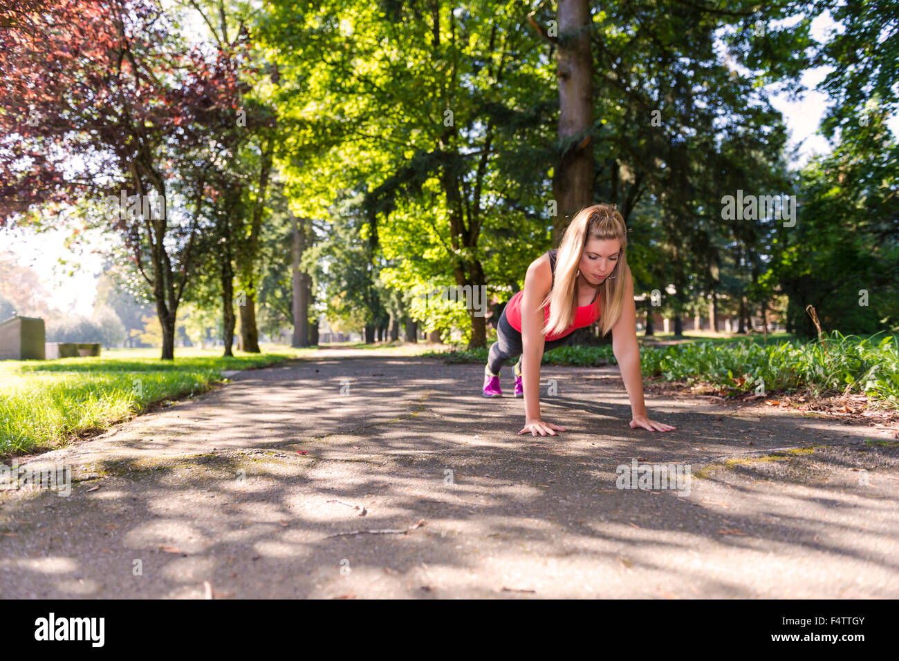 A fit female runner stops to do some pushups in a park Stock Photo - Alamy