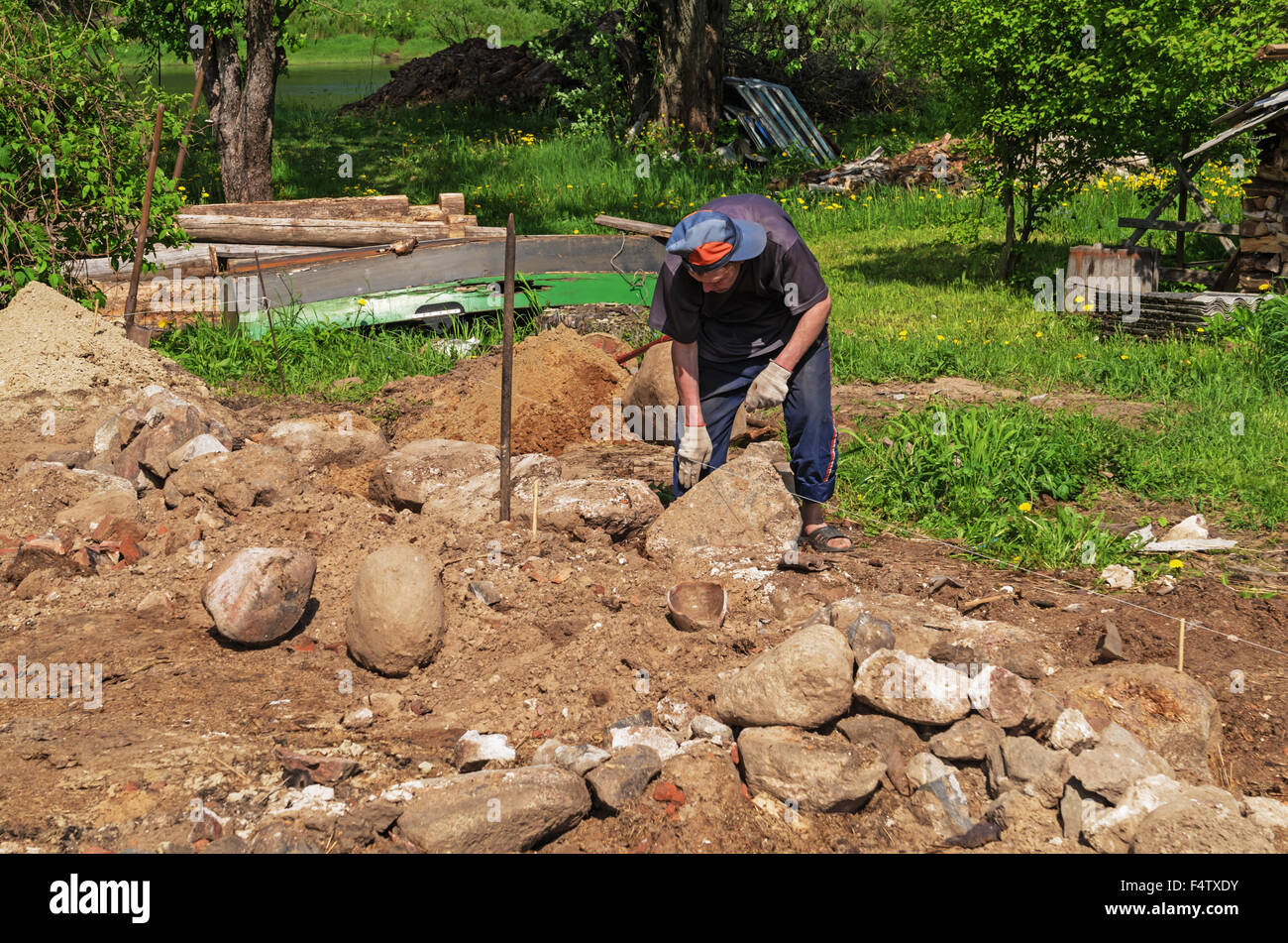 Construction of rural house foundation with use of natural boulders ...