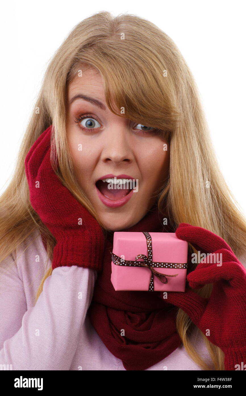 Surprised woman in woolen shawl and gloves with wrapped gift for ...