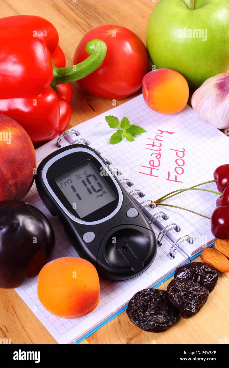 Fresh fruits, vegetables and glucose meter on notebook for writing ...