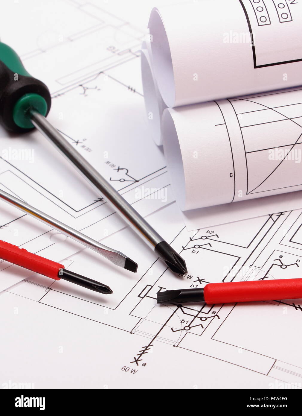 Rolls of diagrams and screwdrivers on electrical construction drawing ...