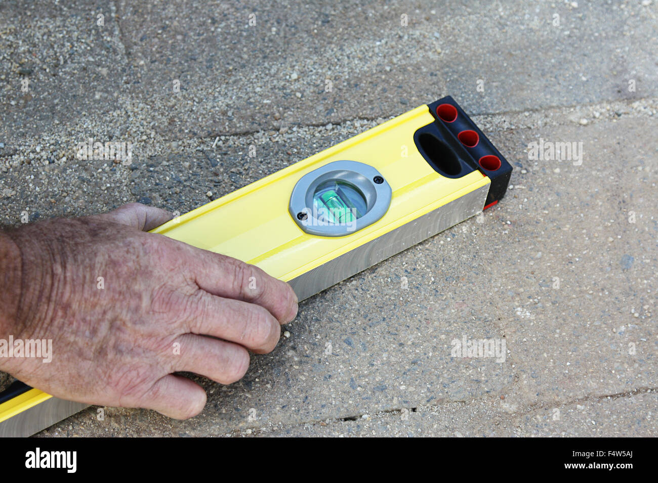a male hand holding a level tool Stock Photo - Alamy