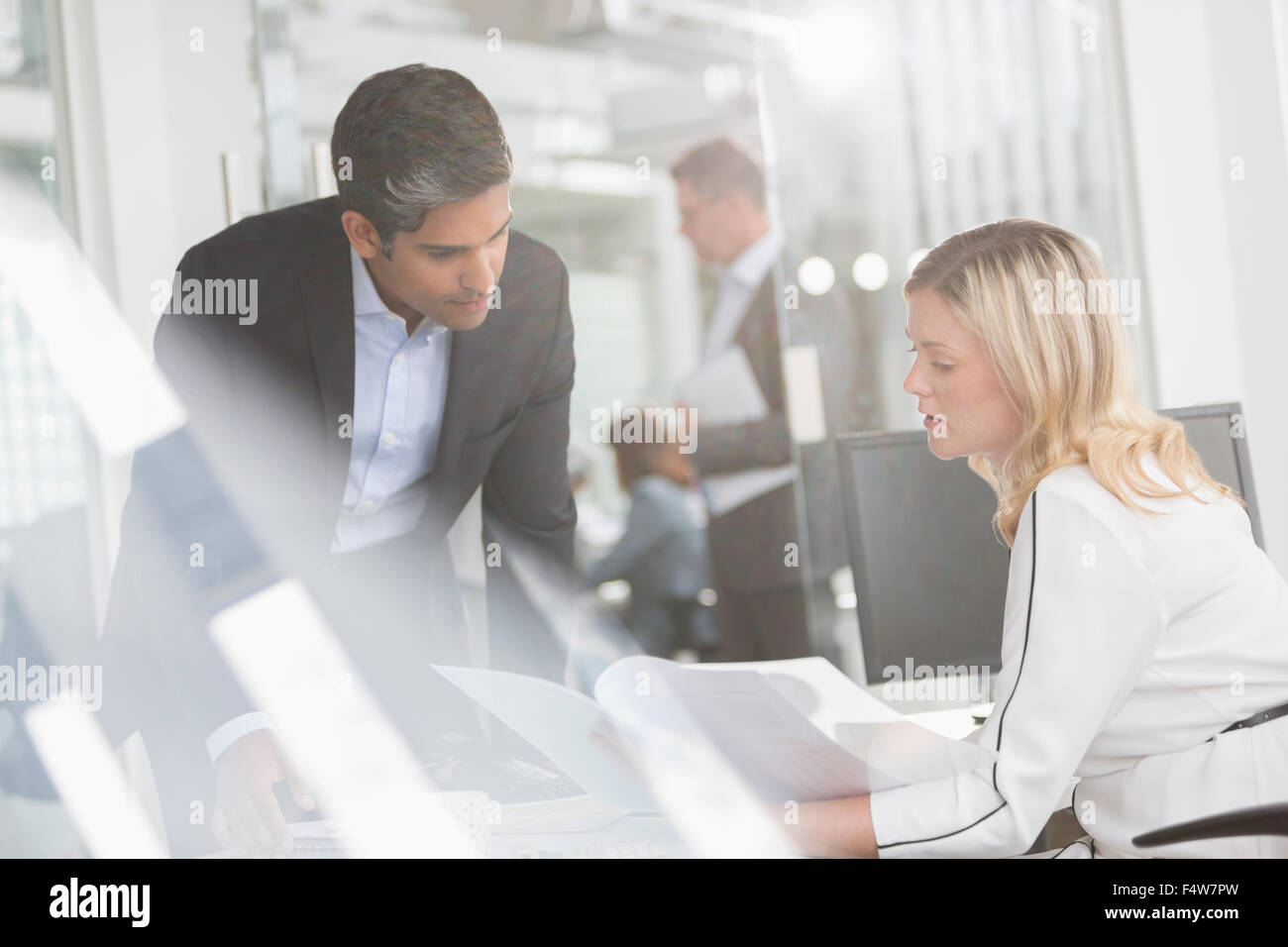Business people reviewing paperwork in conference room Stock Photo - Alamy