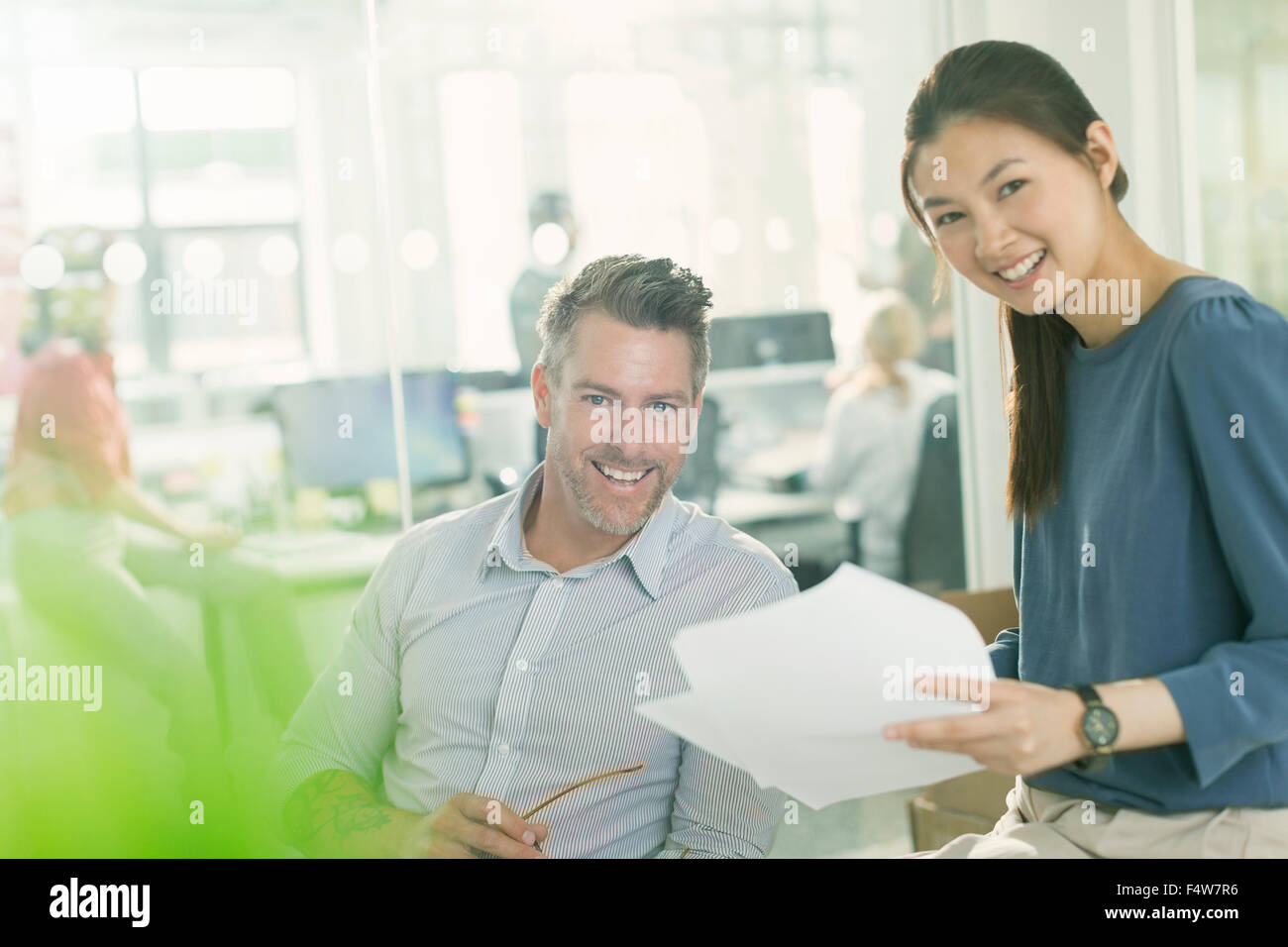 Portrait smiling business people reviewing paperwork in office Stock ...