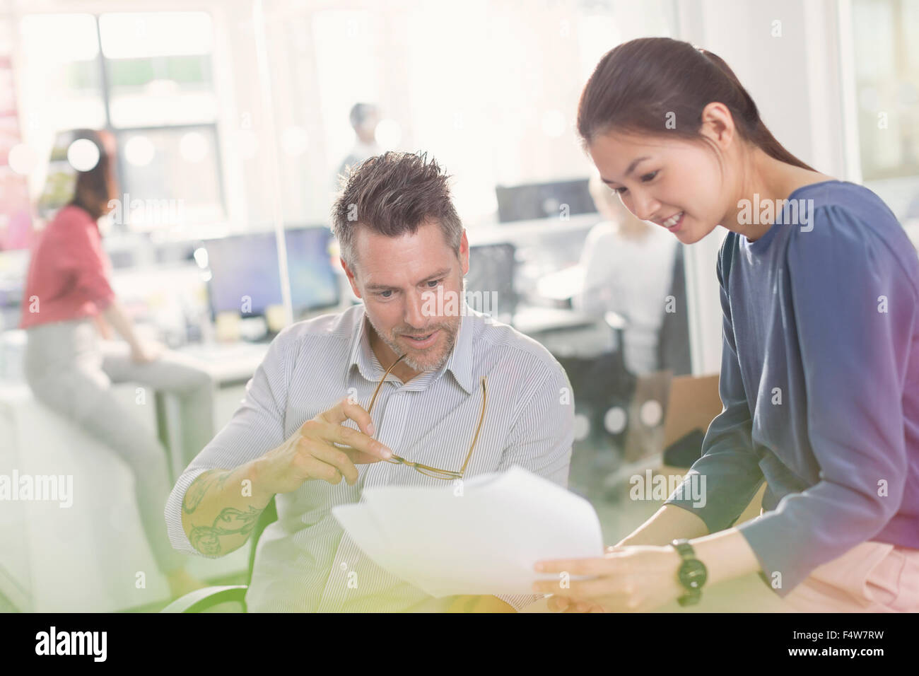 Business people reviewing paperwork in office Stock Photo - Alamy