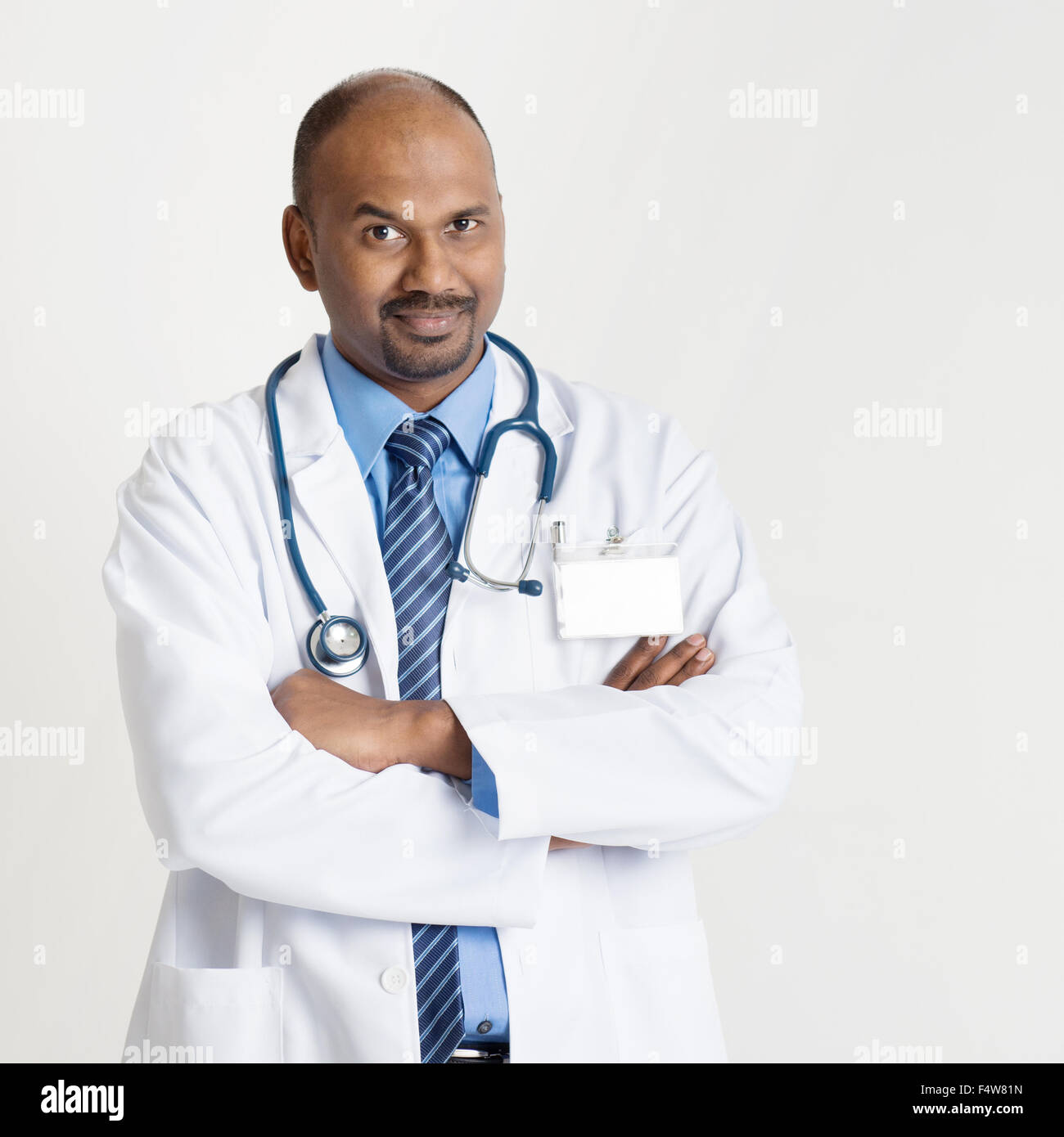 Portrait of mature Indian male medical doctor in uniform standing on ...