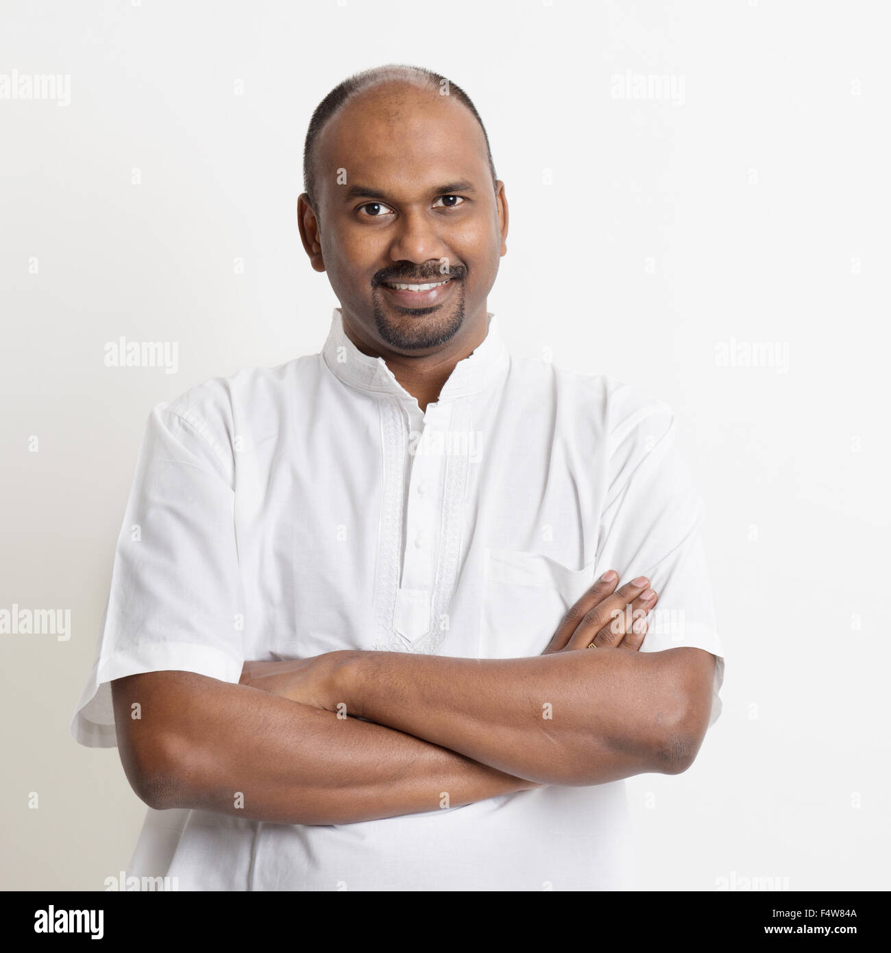 Portrait of mature casual business Indian man smiling, standing on ...