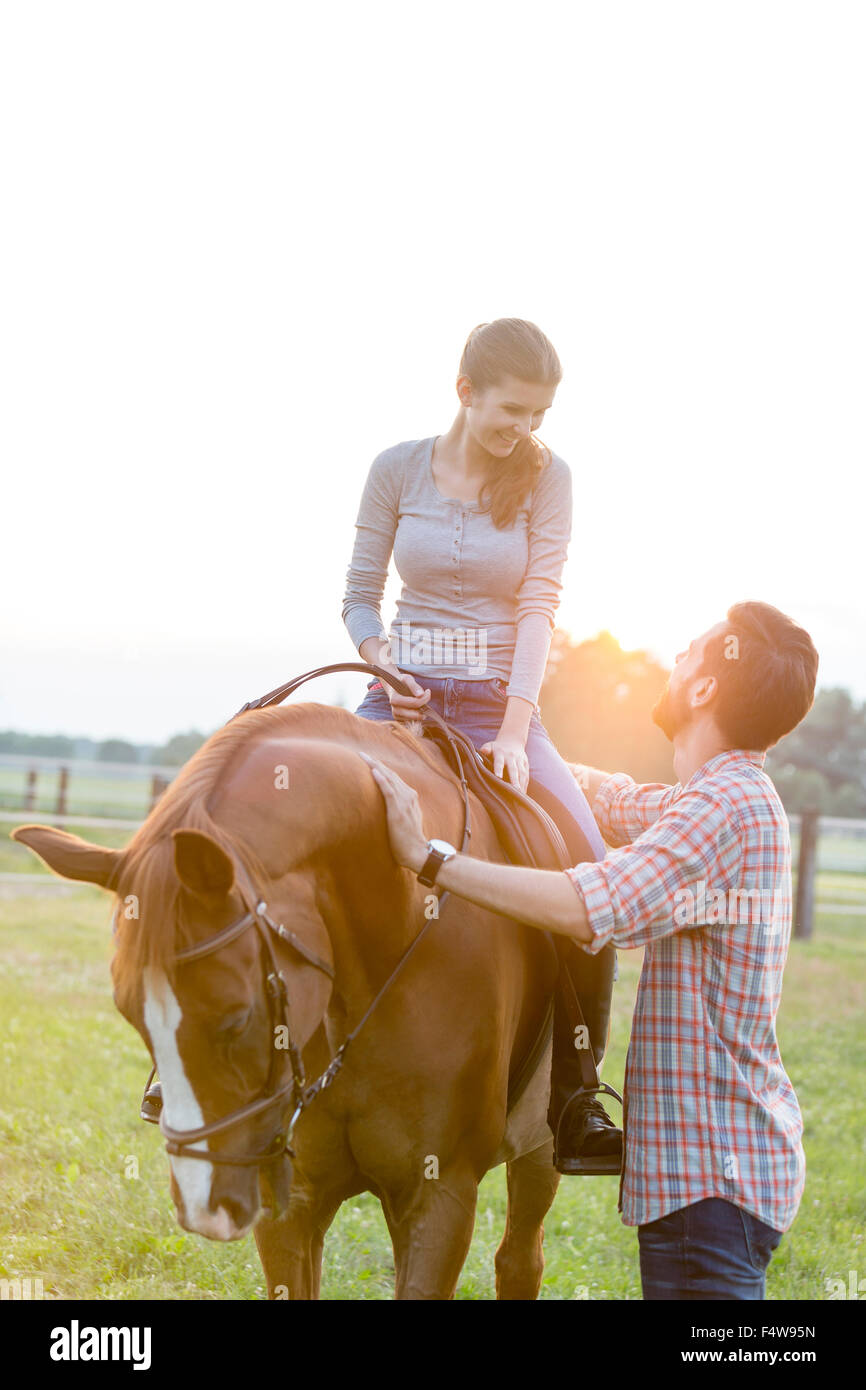 Smiling couple horseback riding in rural pasture Stock Photo - Alamy