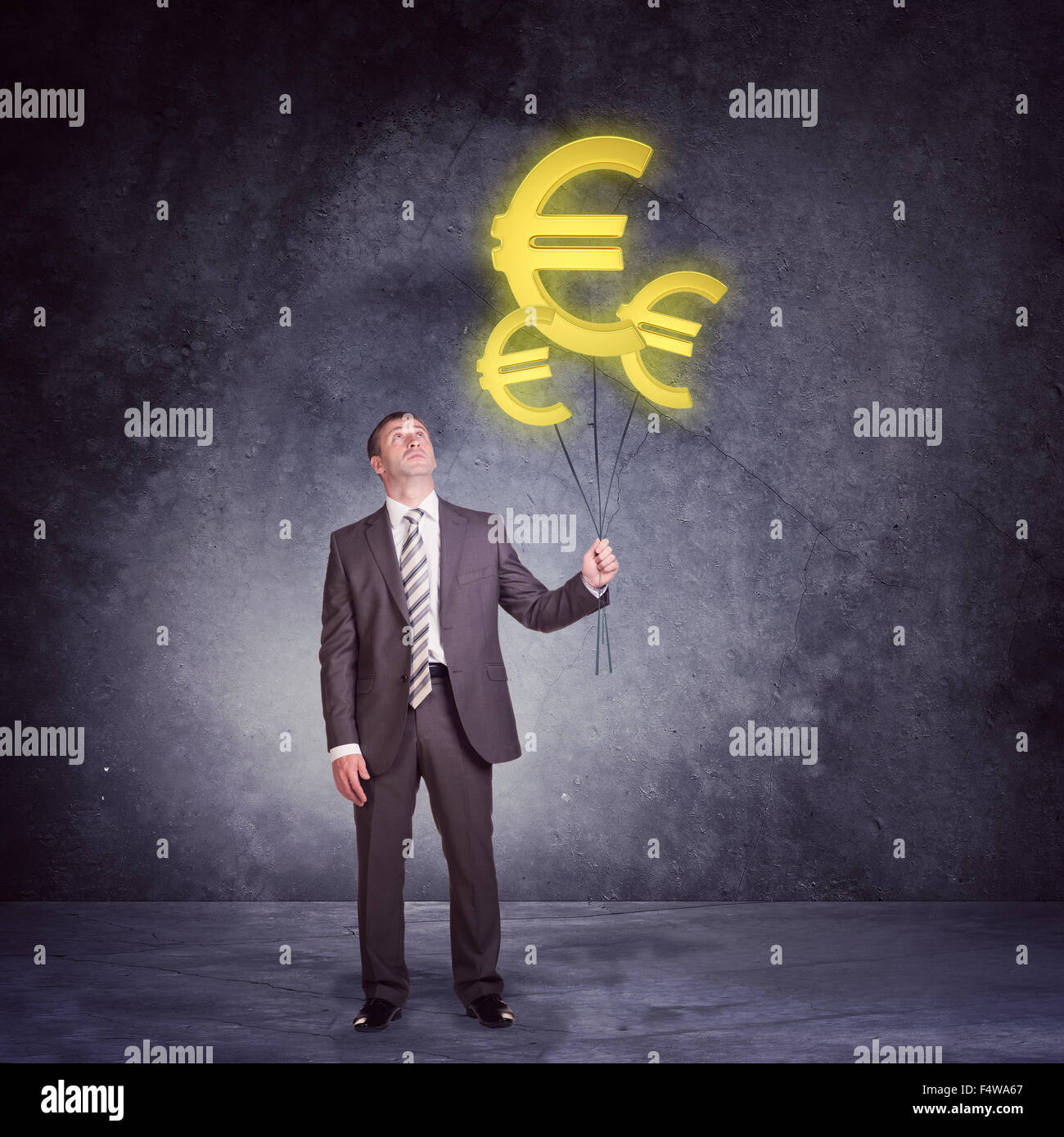 Businessman holding set of big euro signs Stock Photo - Alamy