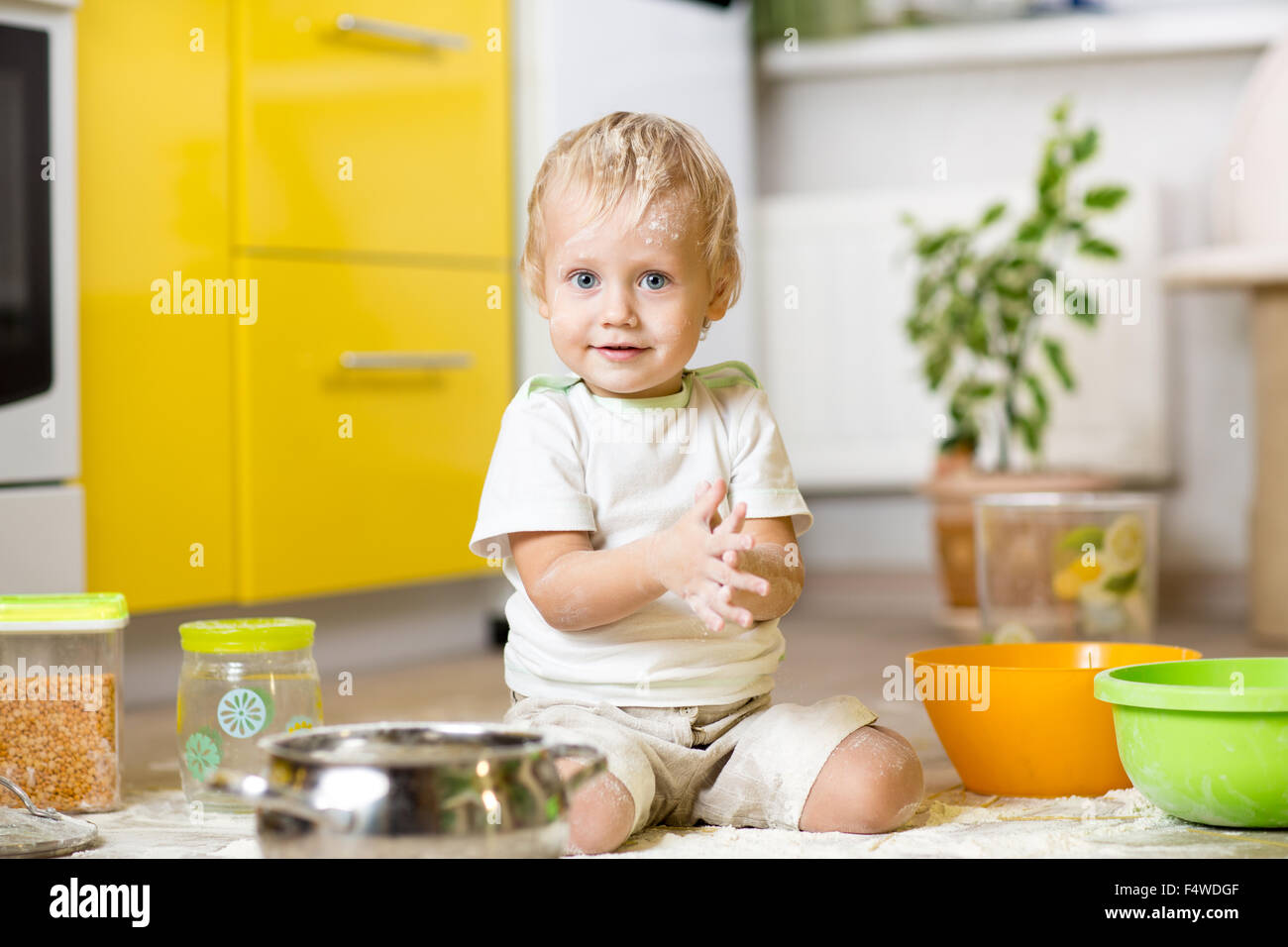 Little boy playing with kitchenware and foodstuffs in kitchen Stock ...