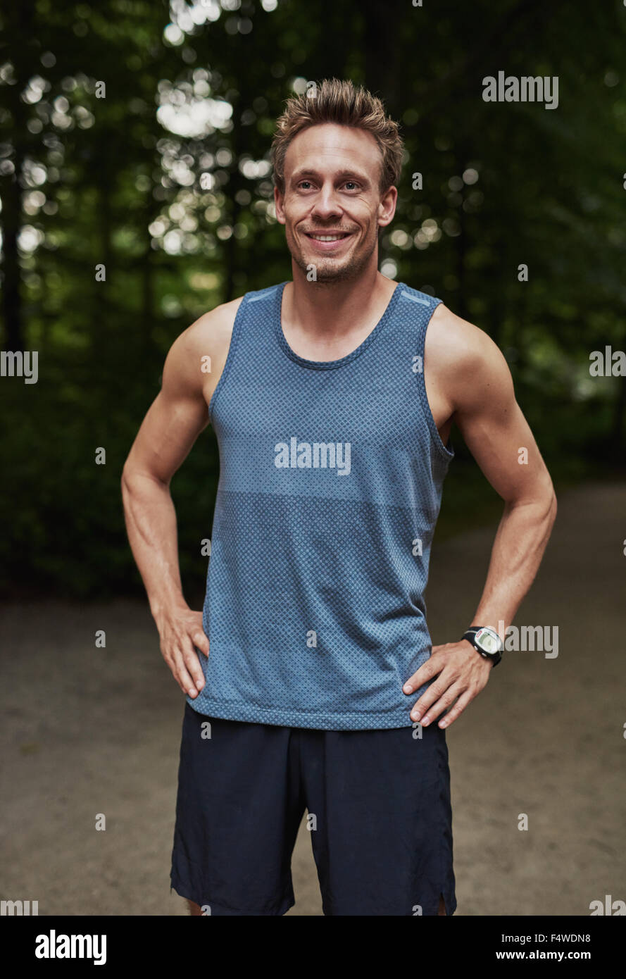 Smiling fit young man enjoying a healthy lifestyle standing outdoors in ...
