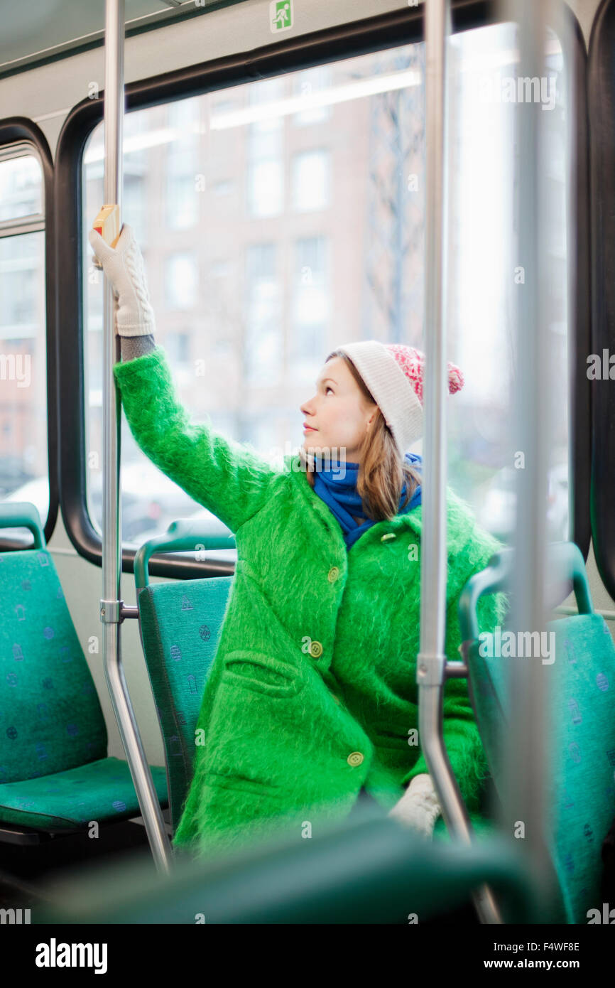 Young woman pressing request stop button in tram Stock Photo - Alamy