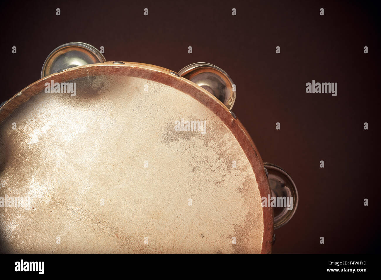 Old retro wooden tambourine on brown background, closeup view of ...