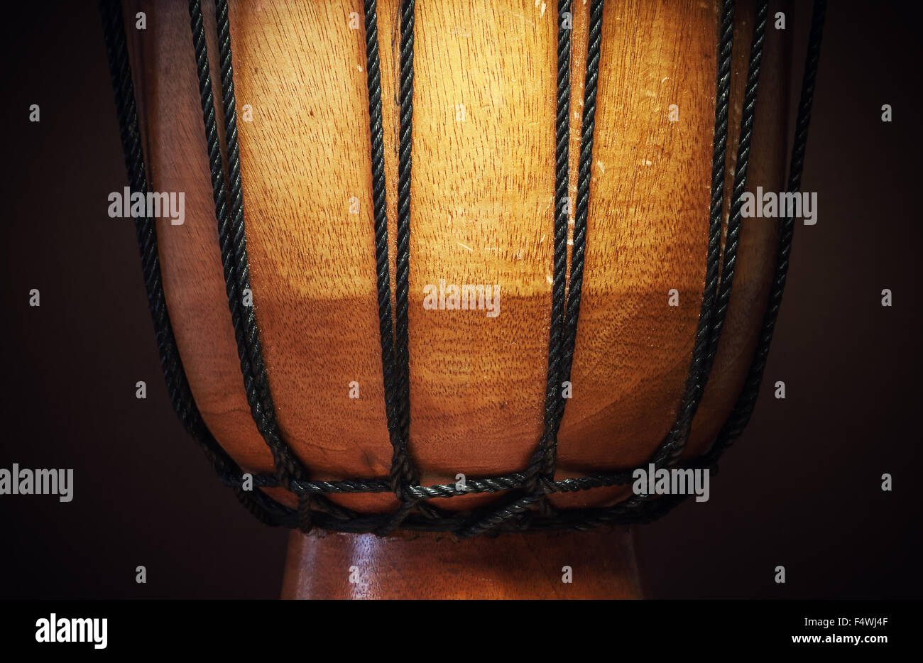 Details of an old wooden djembe, closeup view on ropes, skin and wood ...