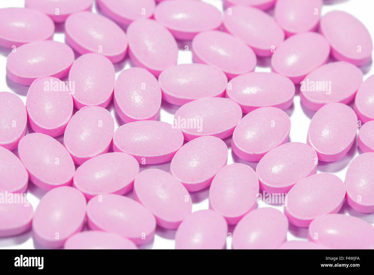 The pink tablets isolated on white background Stock Photo - Alamy