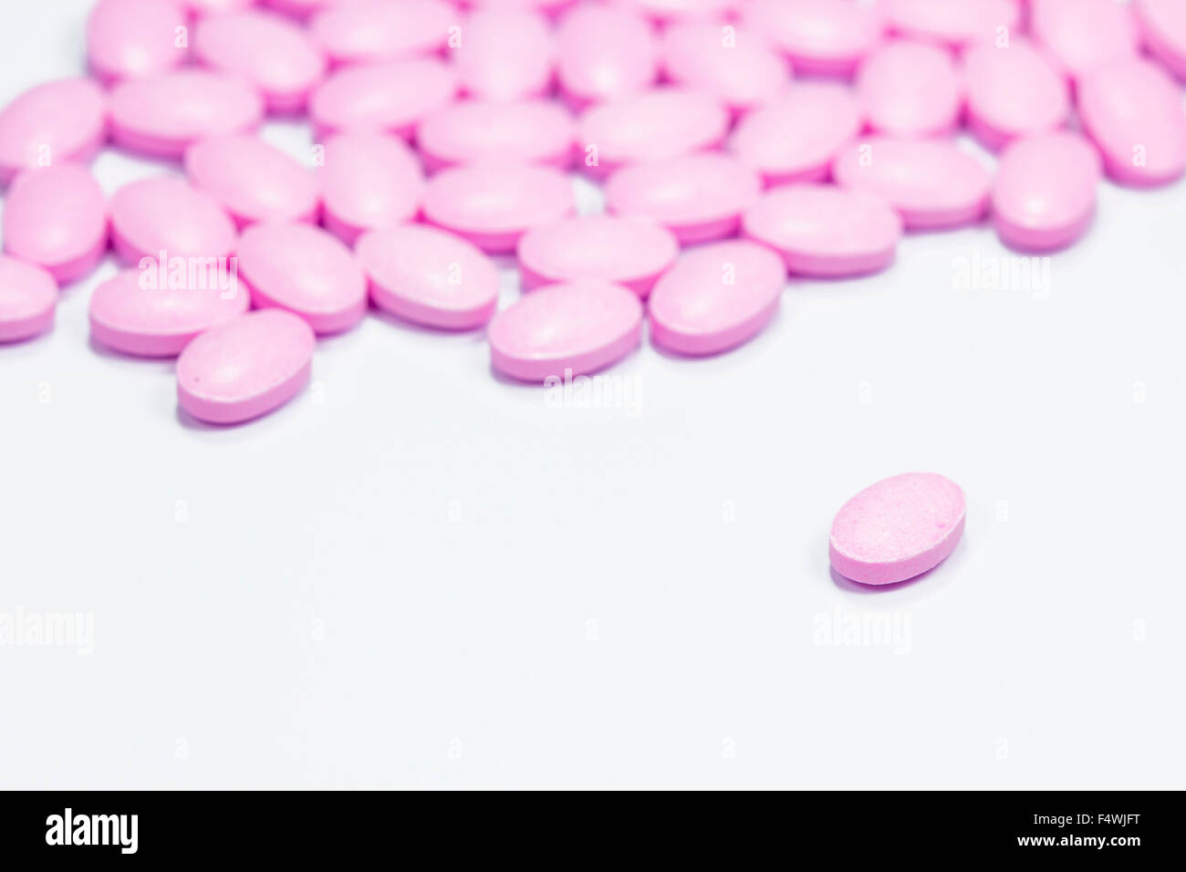 The pink tablets isolated on white background Stock Photo - Alamy
