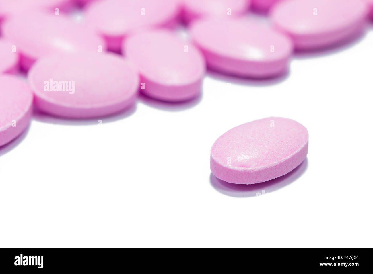 The pink tablets isolated on white background Stock Photo - Alamy
