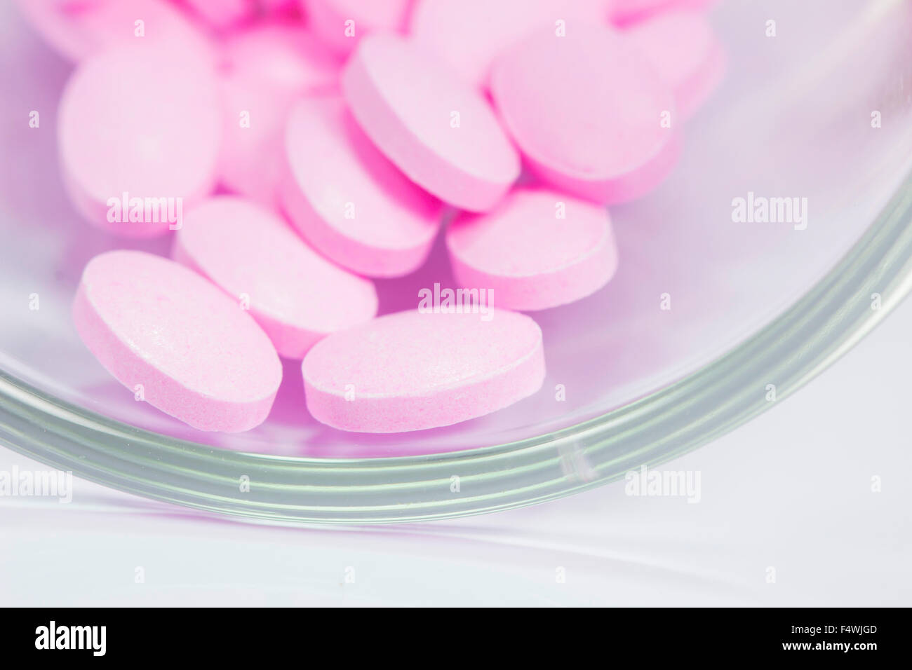 The pink tablets isolated on white background Stock Photo - Alamy