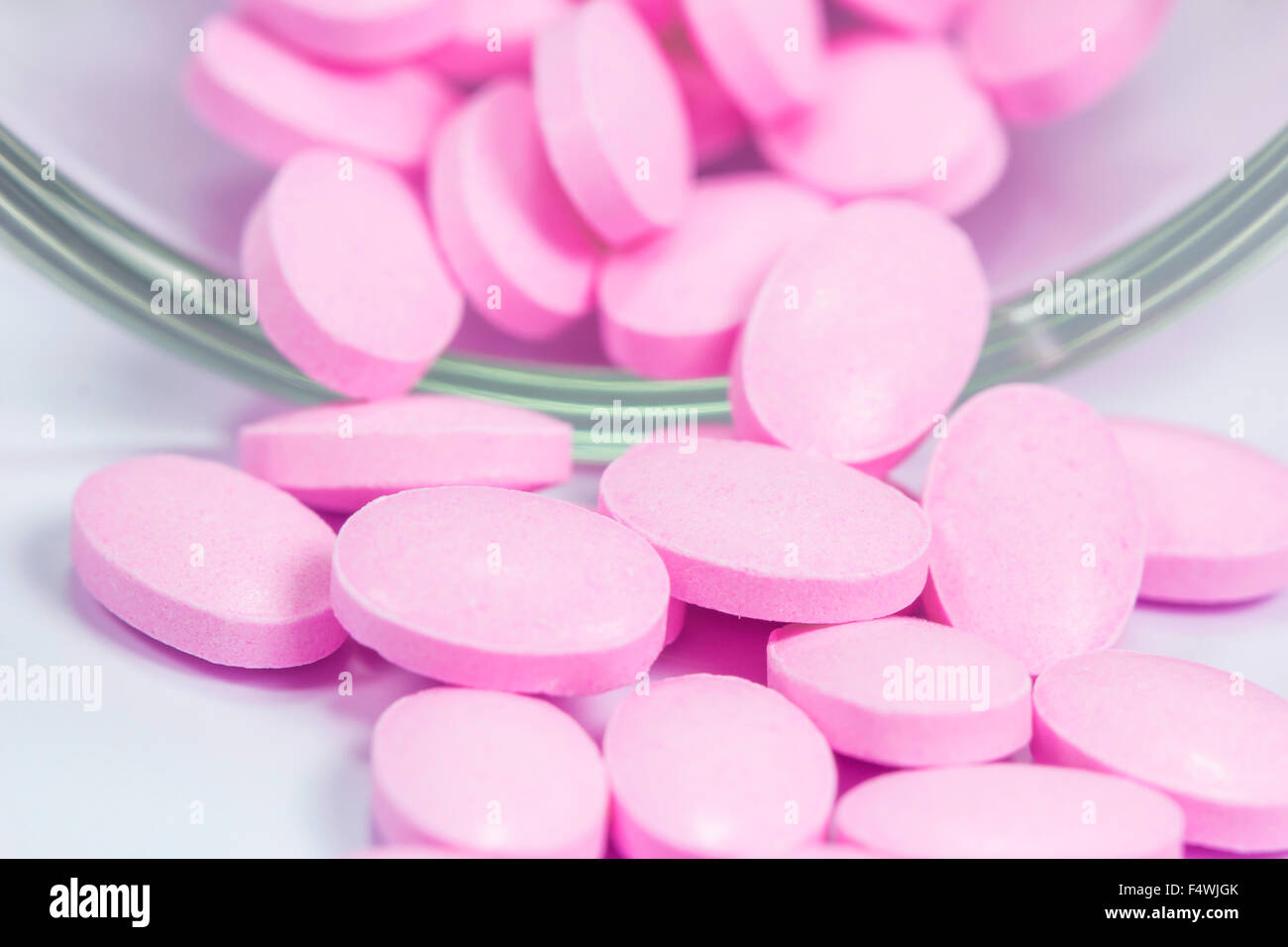The pink tablets isolated on white background Stock Photo - Alamy