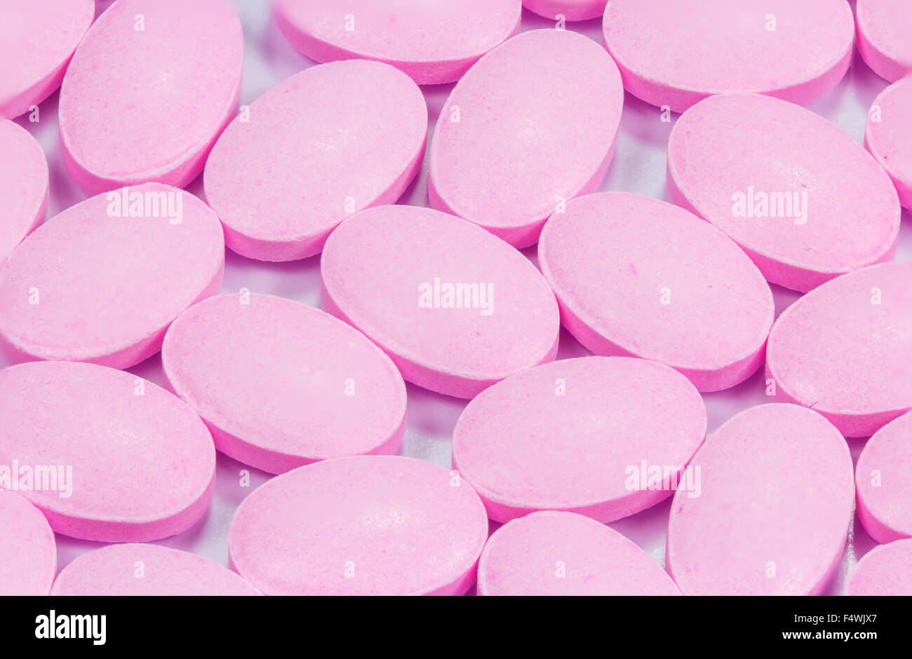 The pink tablets isolated on white background Stock Photo - Alamy