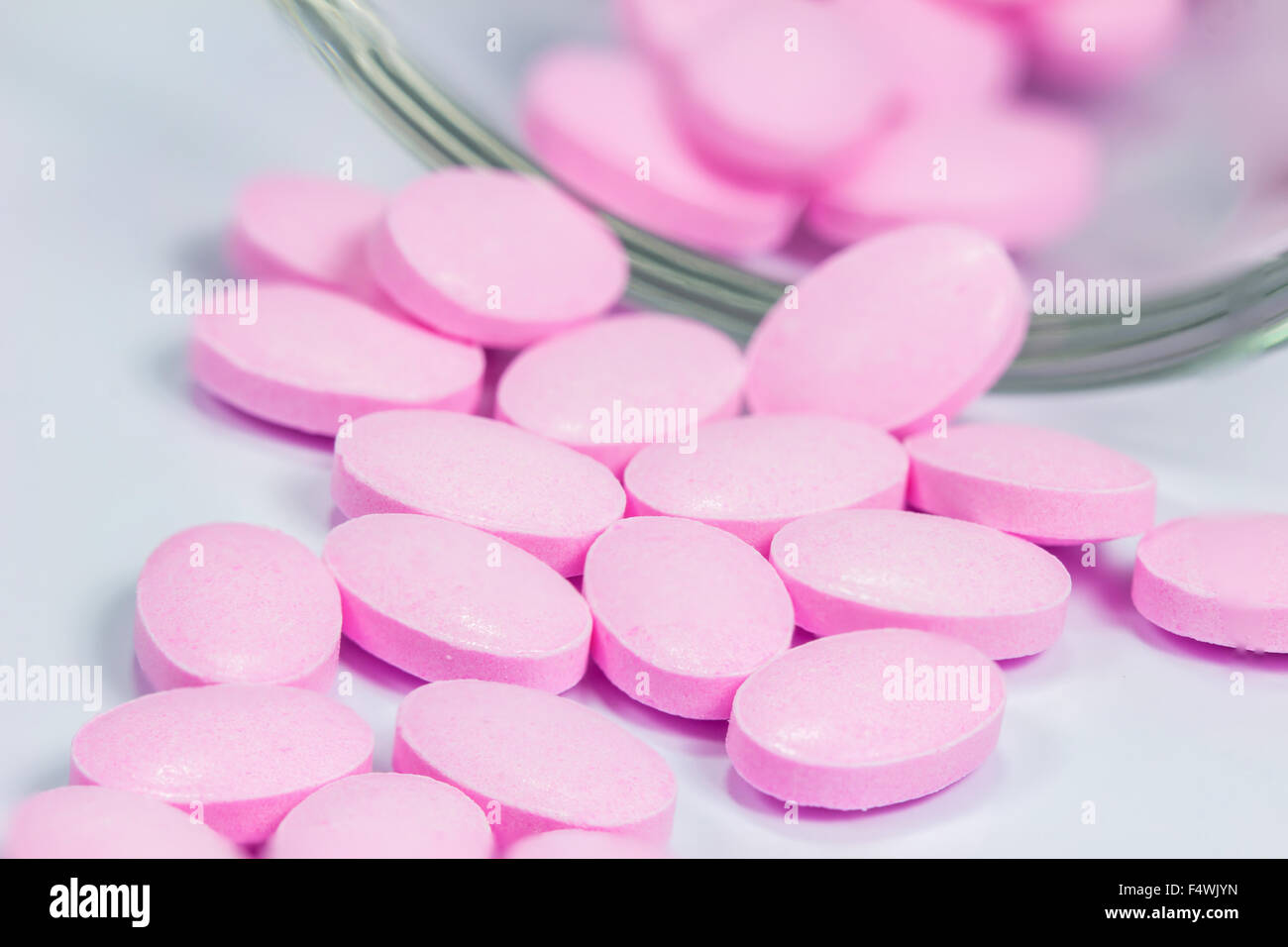 The pink tablets isolated on white background Stock Photo - Alamy