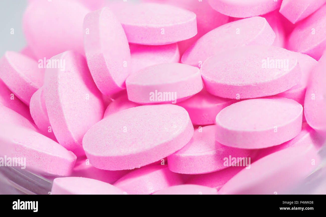 The pink tablets isolated on white background Stock Photo - Alamy
