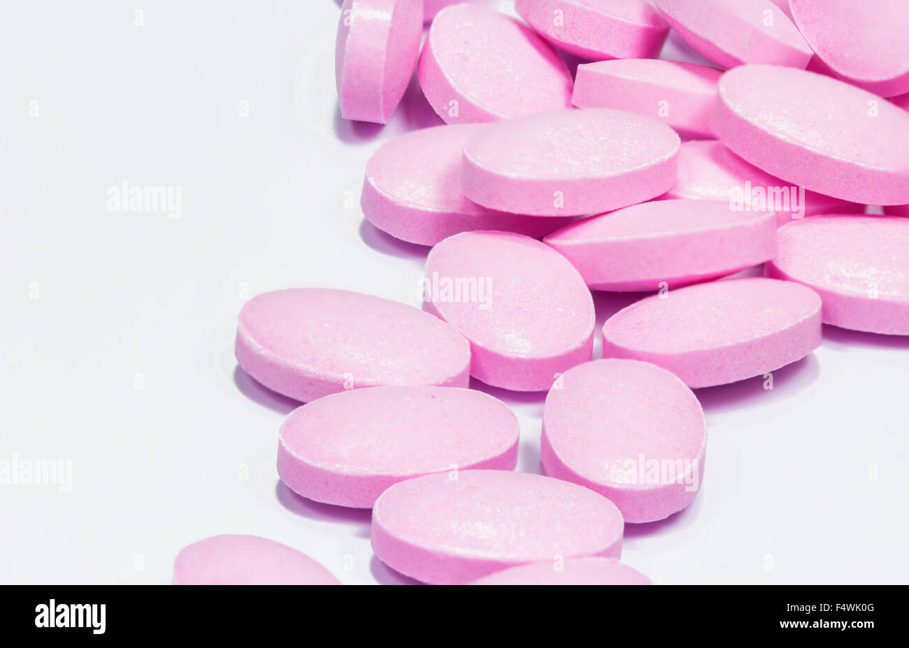 The pink tablets isolated on white background Stock Photo - Alamy