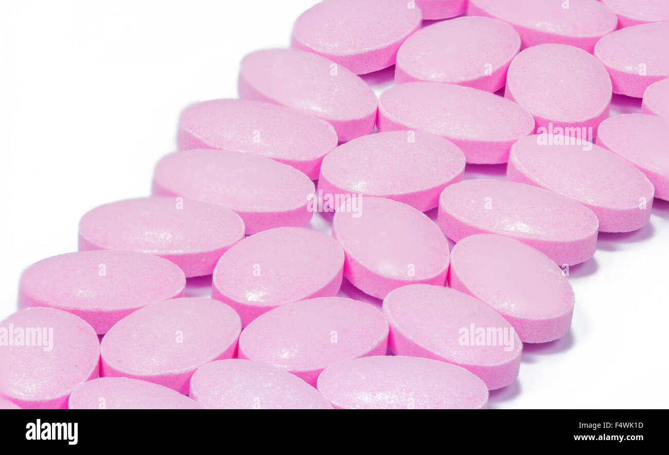 The pink tablets isolated on white background Stock Photo - Alamy
