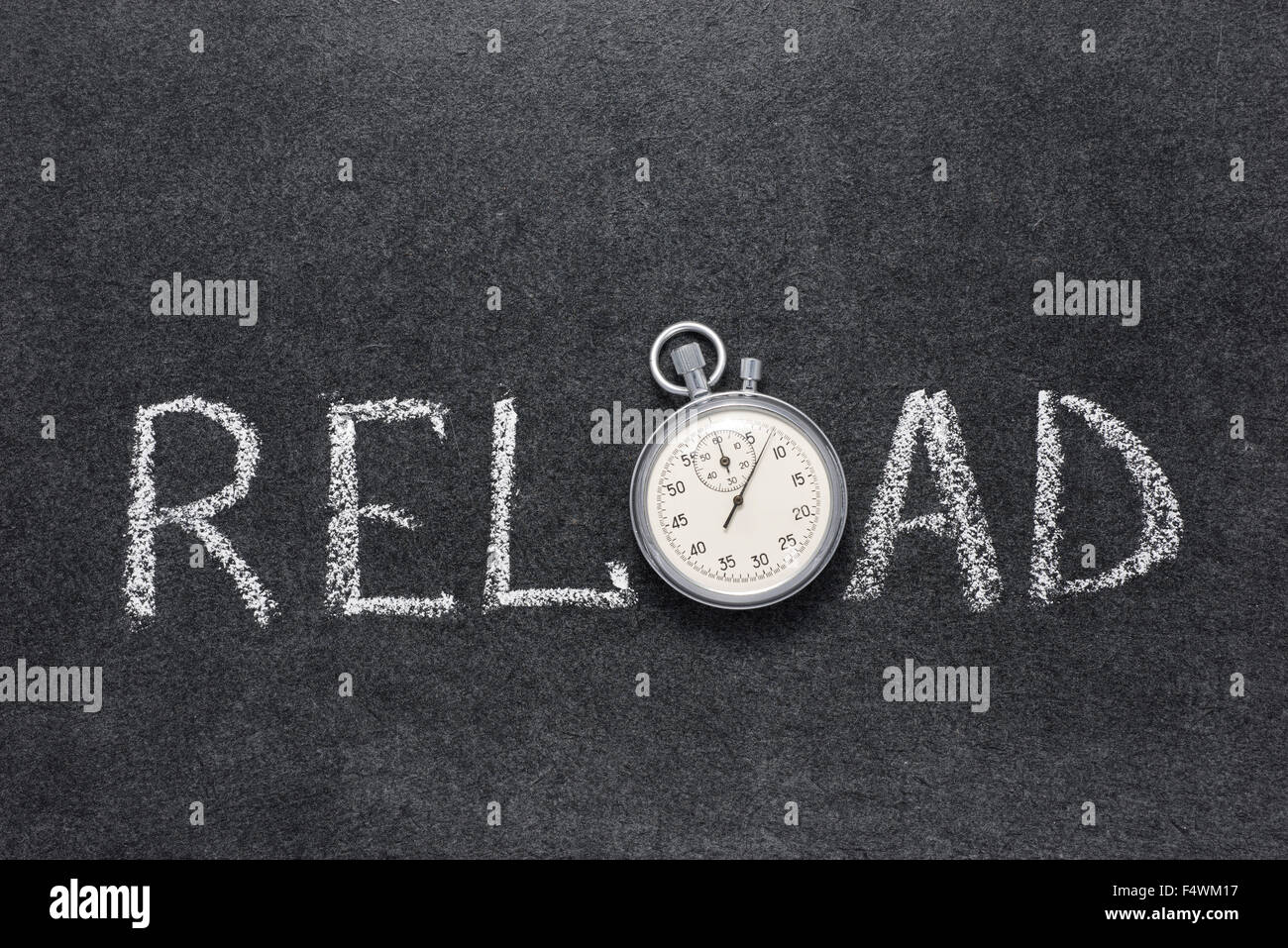 reload word handwritten on chalkboard with vintage precise stopwatch ...