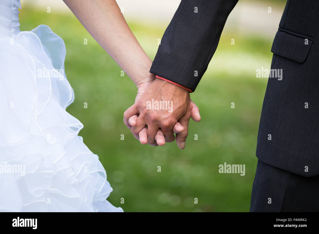 Young married couple holding hands, ceremony wedding day Stock Photo ...