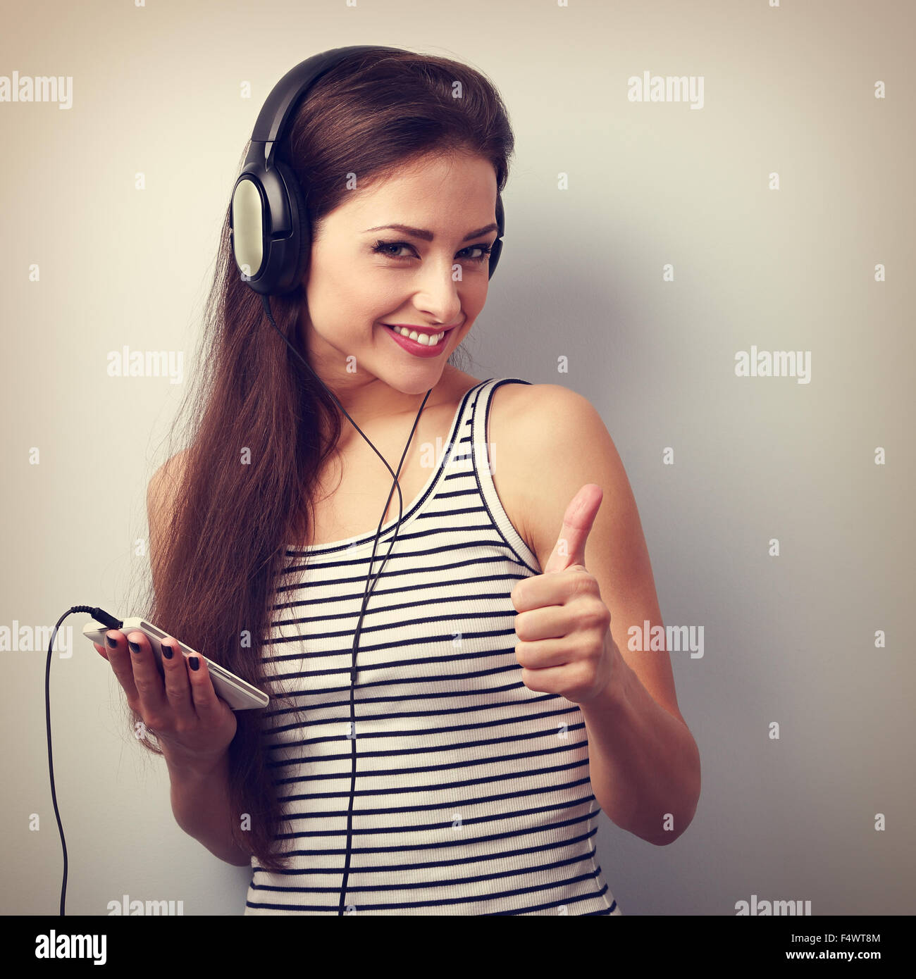 Beautiful happy young woman listen the music holding the phone and ...