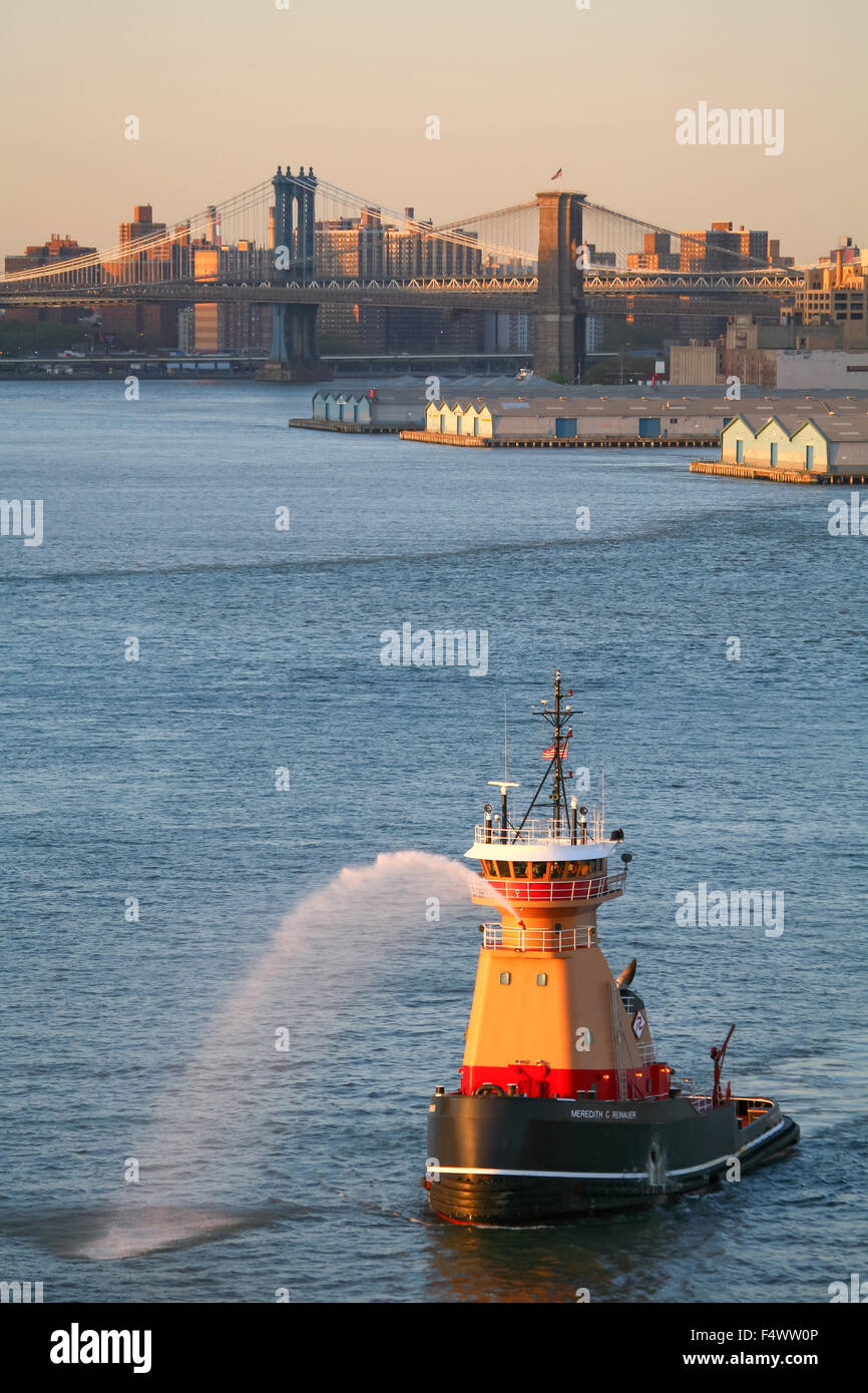 A Meredith C. Reinauer tugboat spraying water and sailing in the East ...