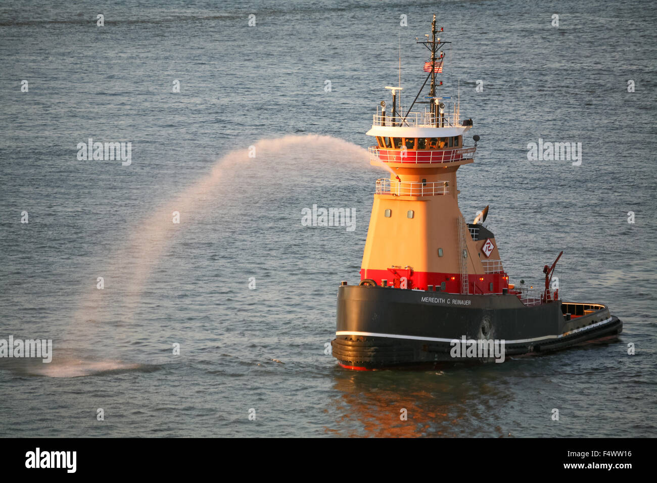 A Meredith C. Reinauer tugboat spraying water and sailing in the East ...