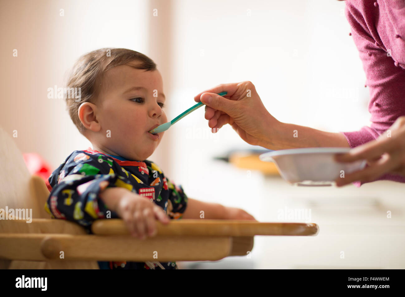 Baby eating food with the help of his mother Stock Photo - Alamy