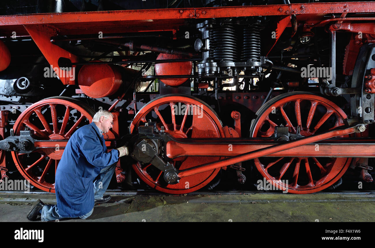 Former railwaymen Werner Kruger shines the bright red wheels of a steam ...