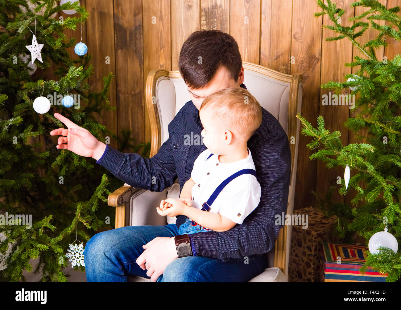 Happy father and son near the Christmas tree Stock Photo - Alamy