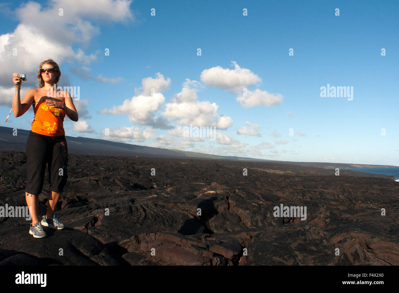 Girl taken pictures to the Black lava mountains near the coast and ...