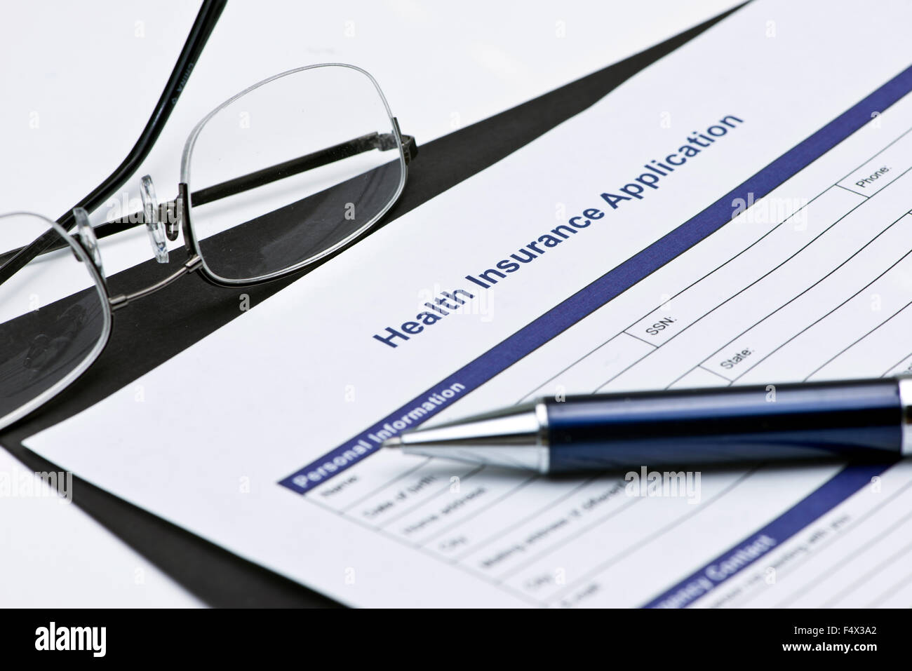 Health insurance application with glasses, and pen Stock Photo - Alamy
