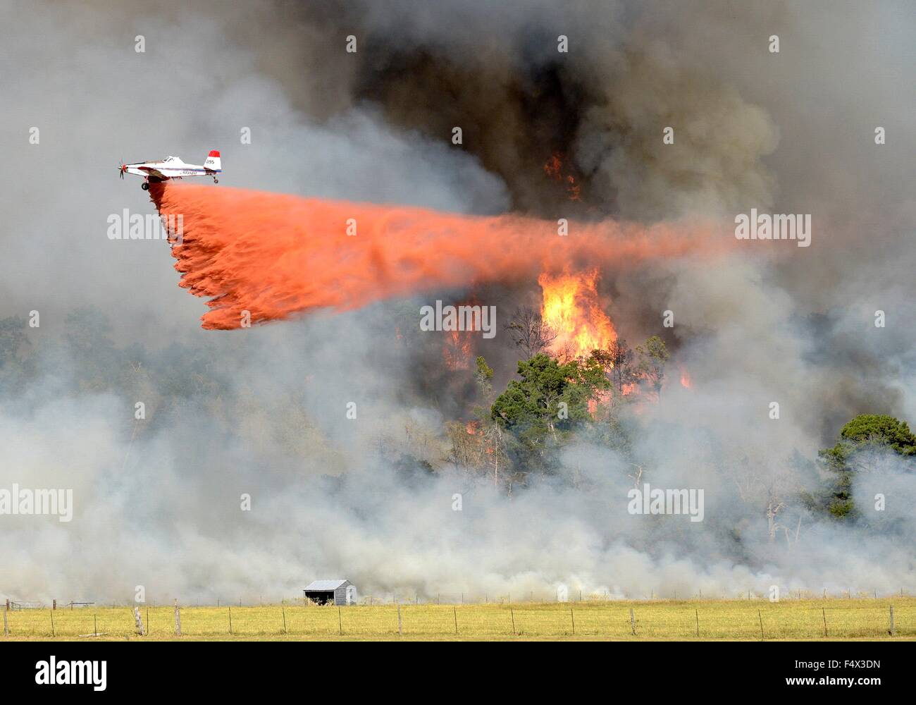 A firefighting aircraft releases flame retardant during a aerial drop ...