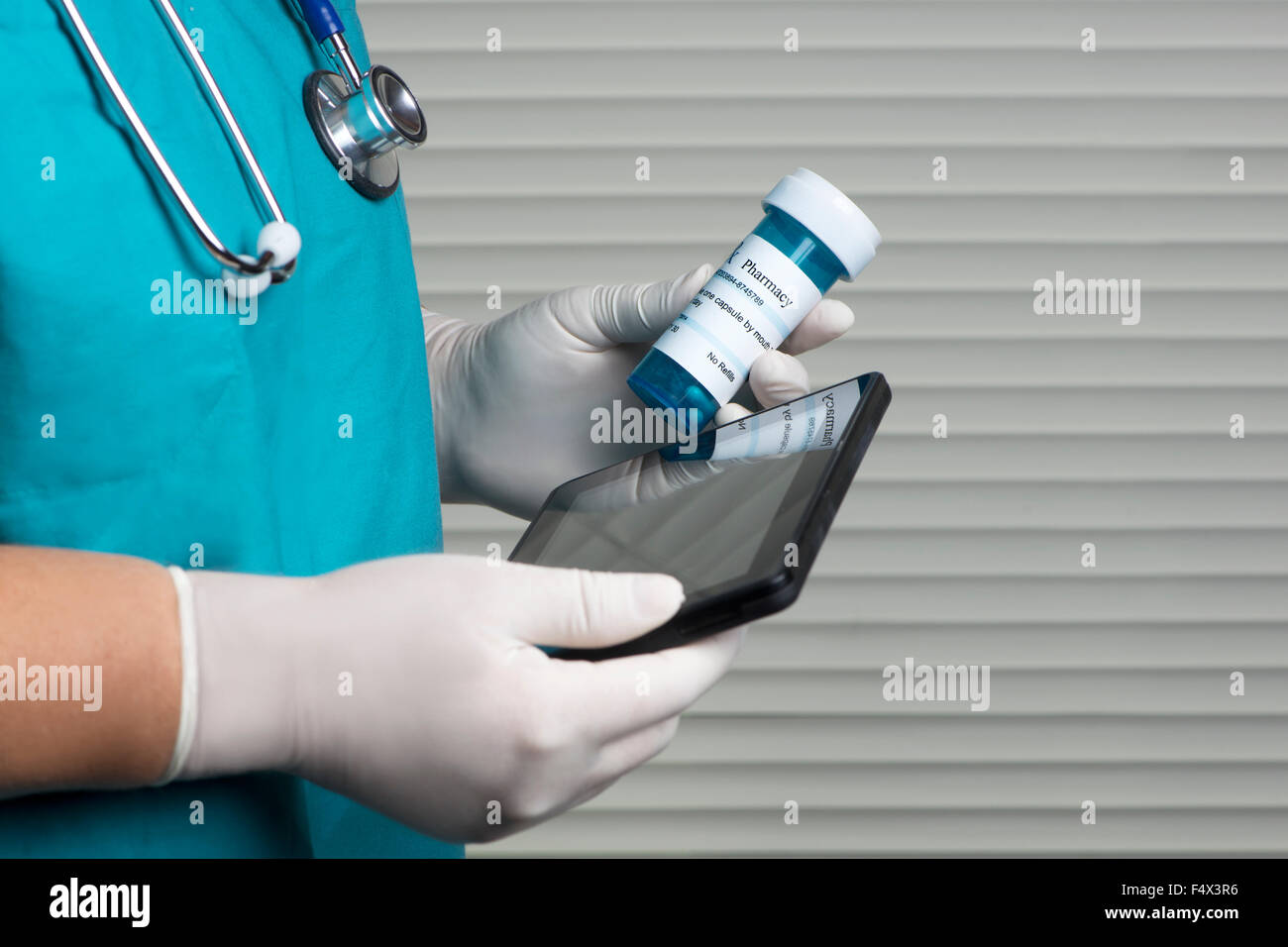 Nurse checks prescription bottle using tablet computer Stock Photo - Alamy