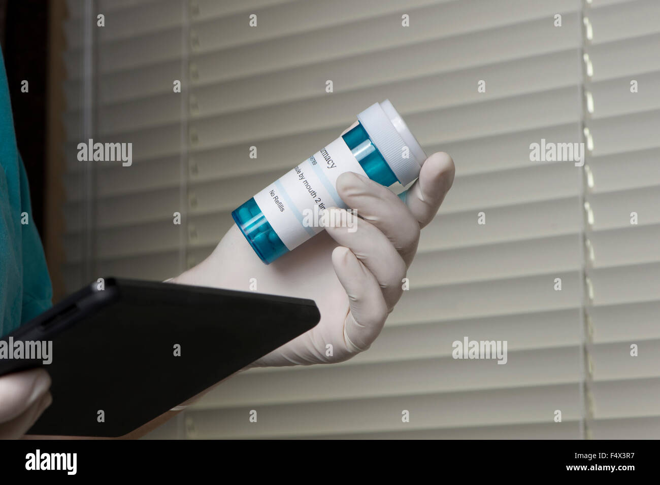 Nurse checks prescription bottle using tablet computer Stock Photo - Alamy