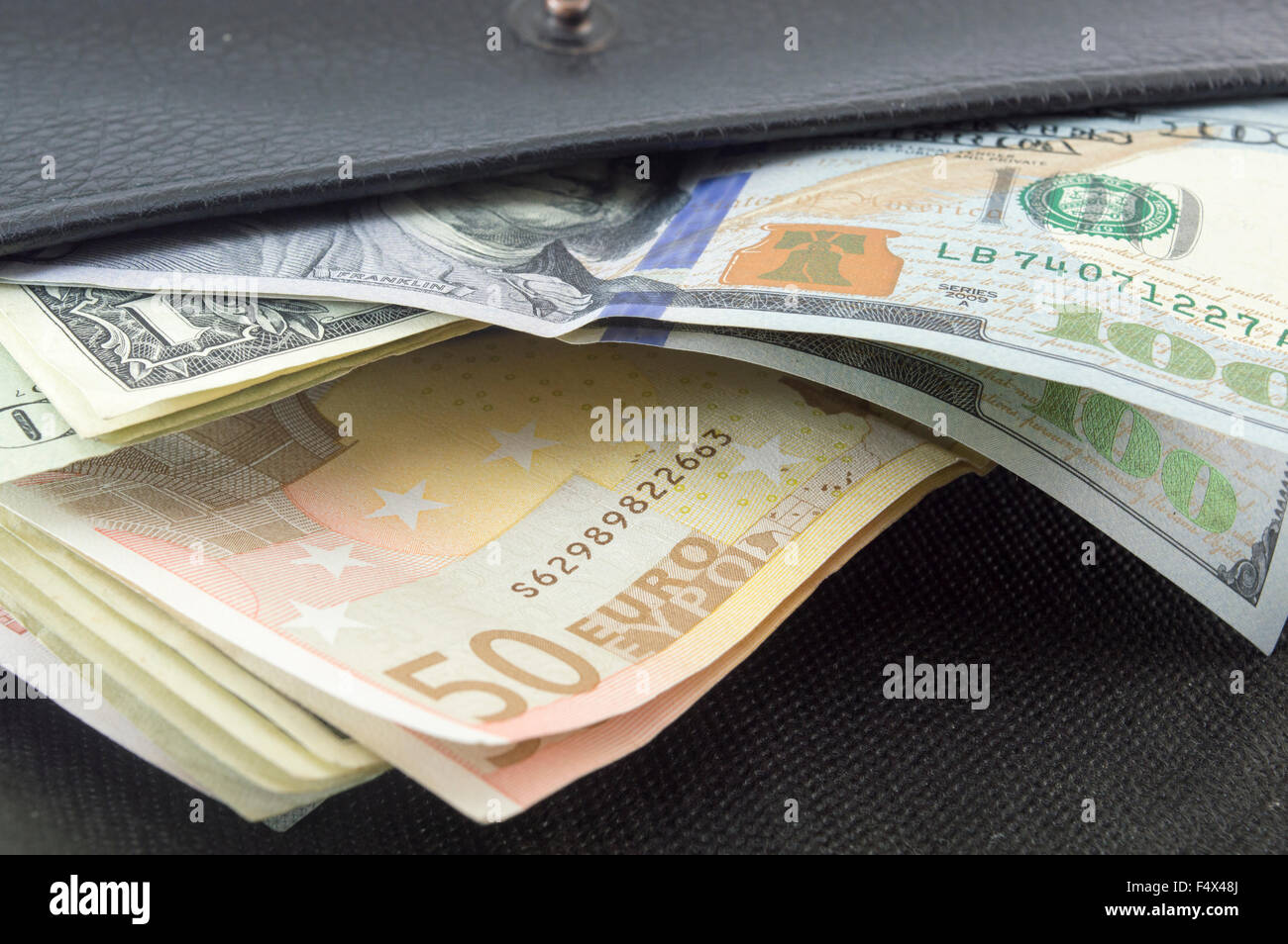 Various euro and dollar bills in a black wallet Stock Photo - Alamy