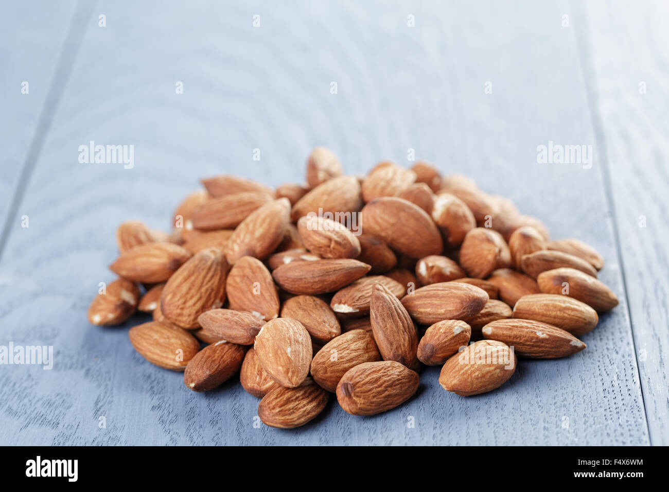 roasted almonds on blue wooden table Stock Photo - Alamy