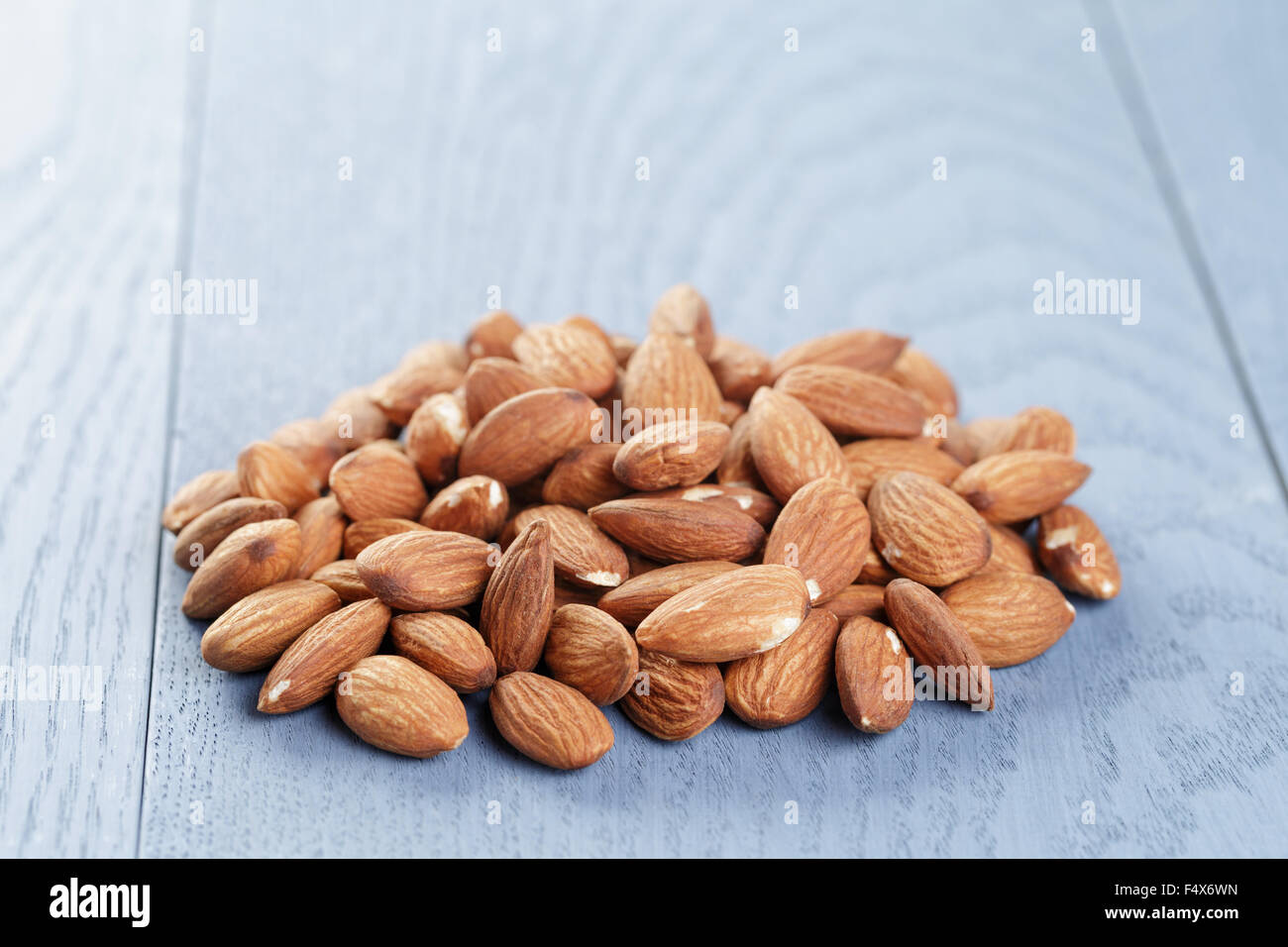 roasted almonds on blue wooden table Stock Photo - Alamy