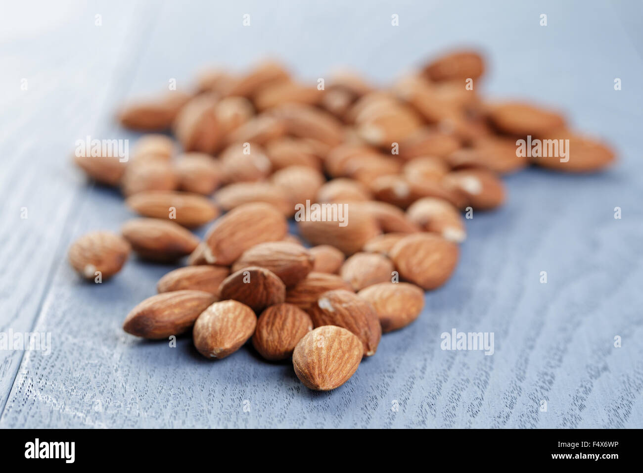 roasted almonds on blue wooden table Stock Photo - Alamy