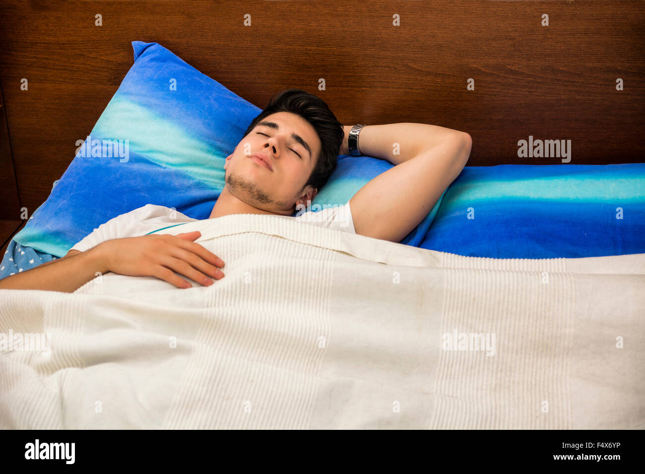 Handsome young man sleeping on white pillow Stock Photo - Alamy