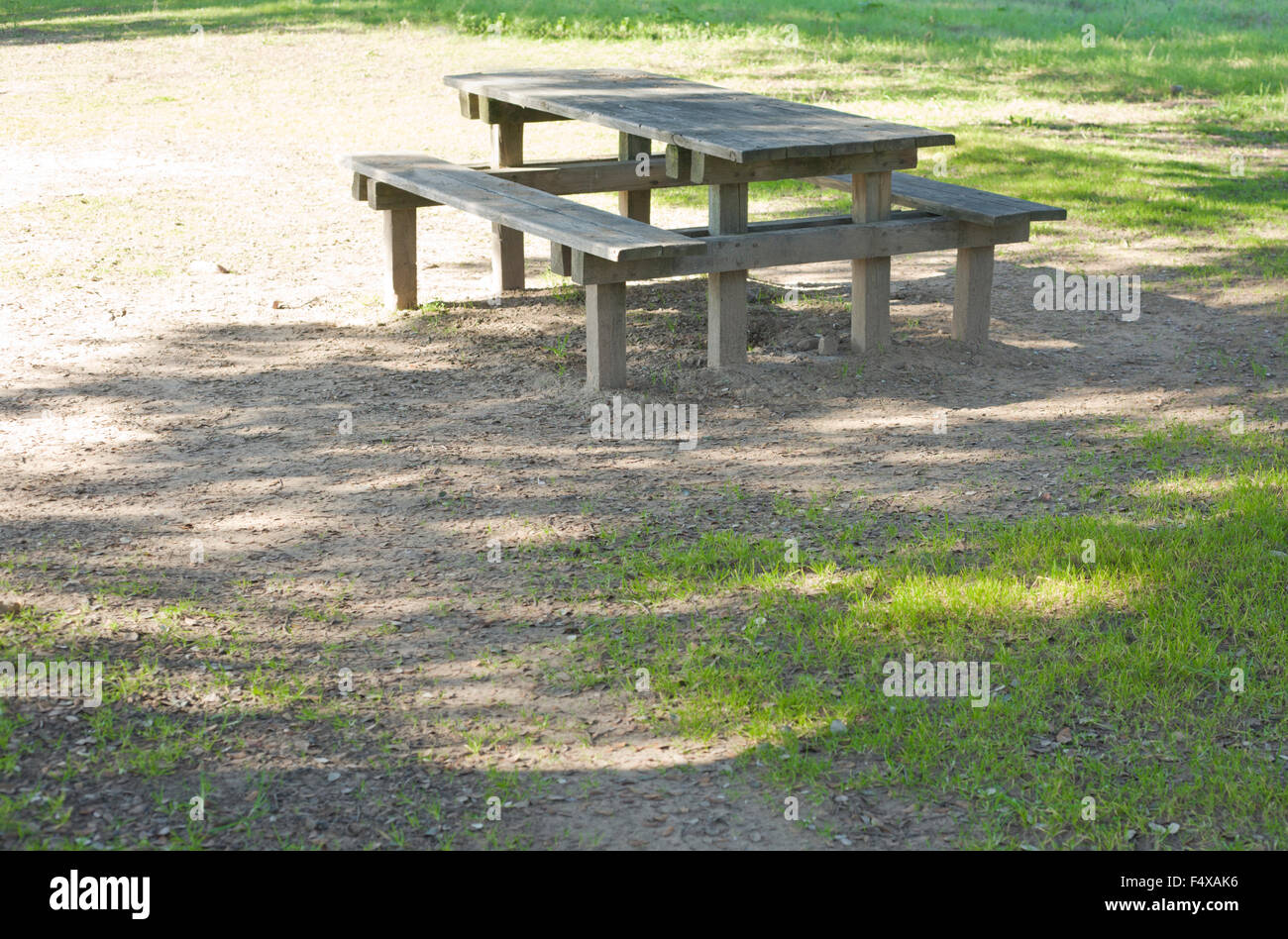 Wooden picnic table in field with trees at sunset on dehesa landscape ...