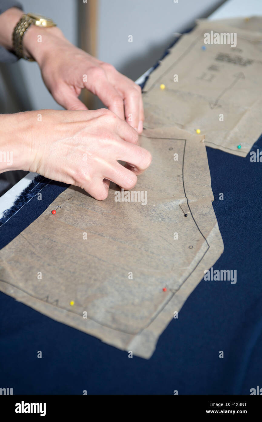 Preparing sewing pattern pieces to be cut from dark blue material Stock ...