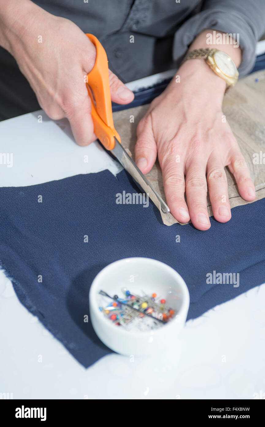 Cutting out cloth pieces from a sewing pattern Stock Photo - Alamy