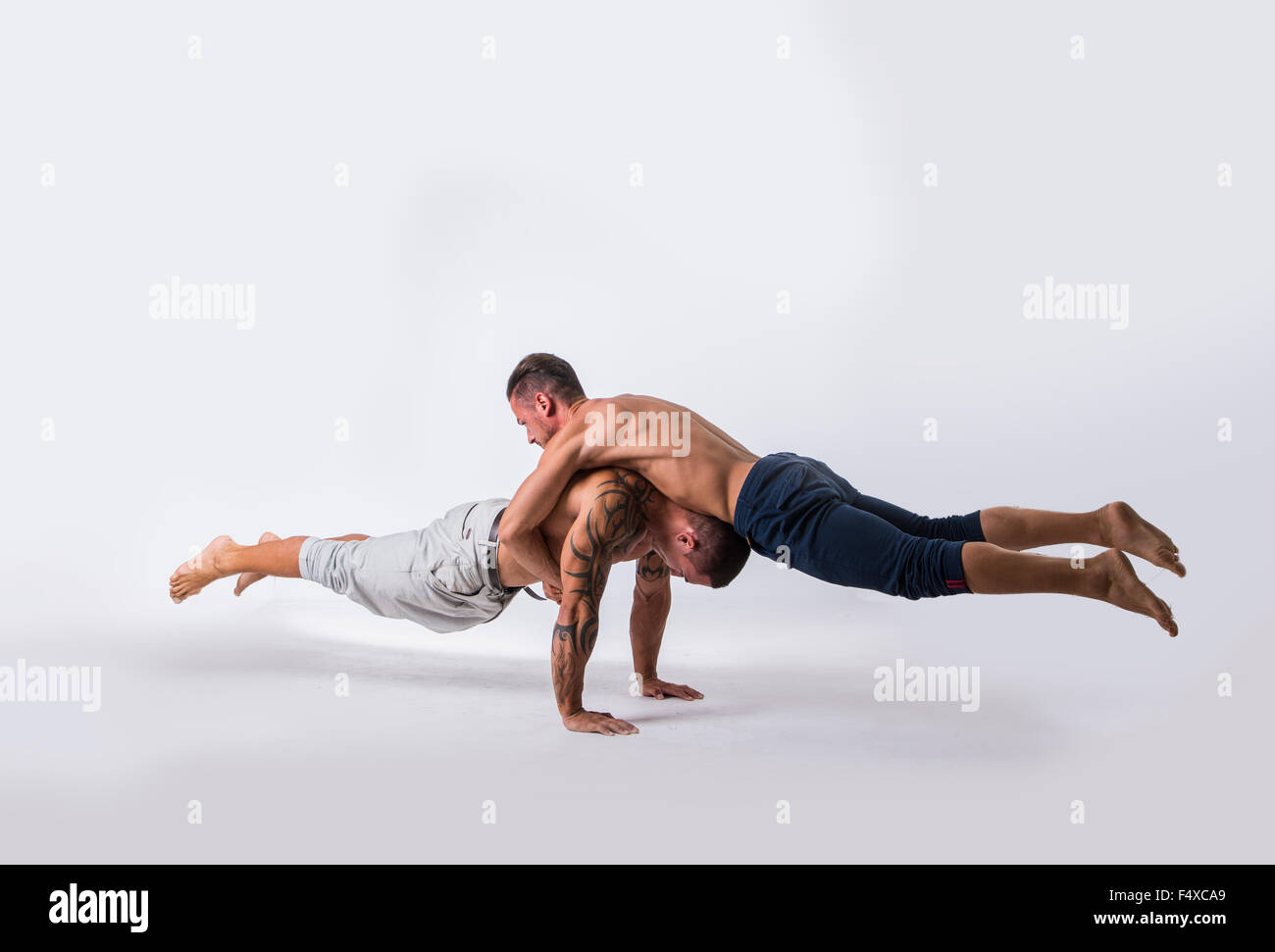 Muscular Shirtless Male Acrobatic Dancers Balancing on Top of Each ...